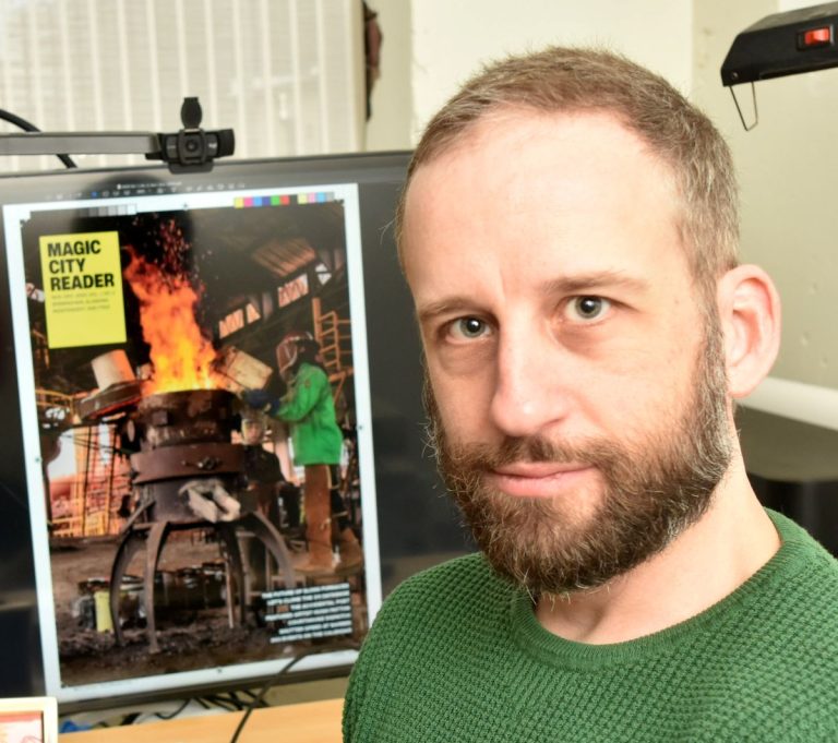 The second edition of Magic City Reader is on the screen behind founder ...